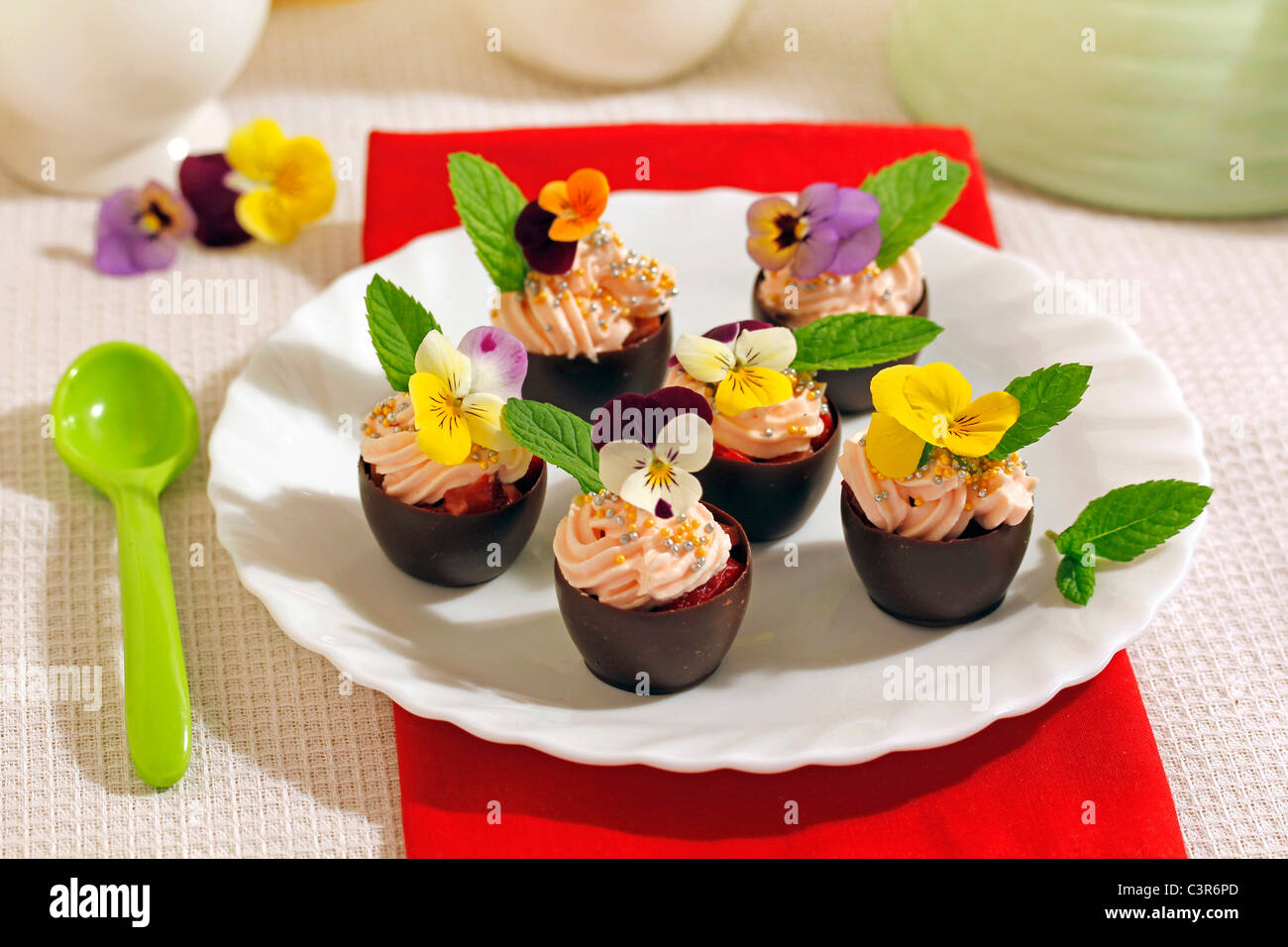 Chocolate cups with cream and flowers. Recipe available Stock Photo - Alamy