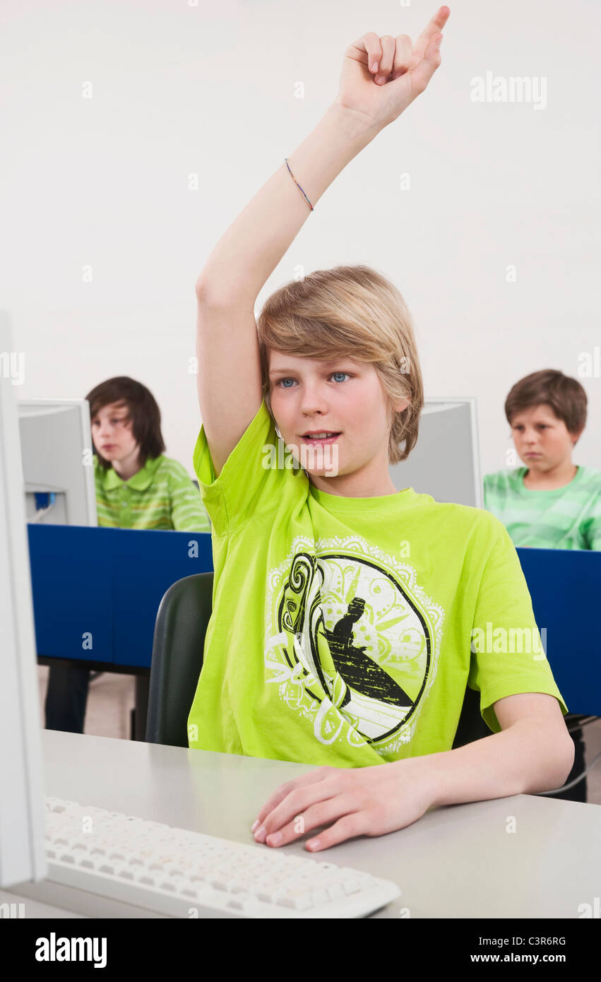 Germany, Emmering, Teenage boy (14-15) hand raised with students using ...