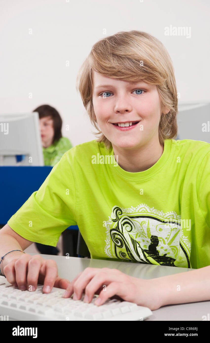 Germany, Emmering, Teenage boy (14-15) using computer with student in ...