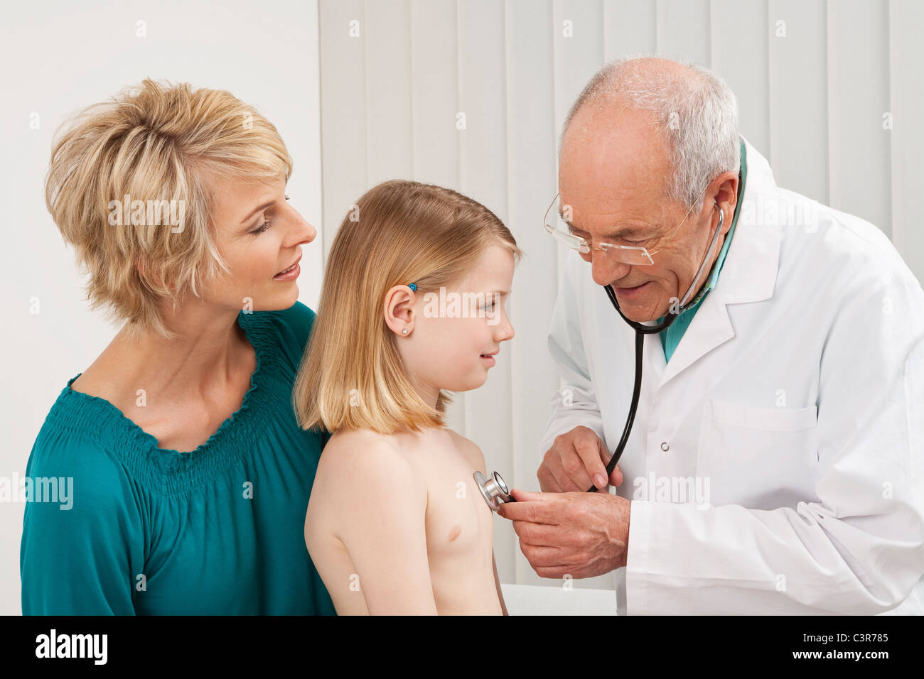 Germany, Munich, Doctor examining girl (8-9) with woman Stock Photo - Alamy