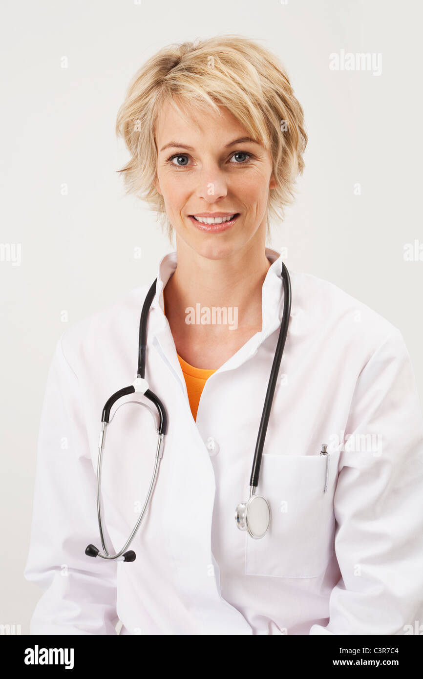 Germany, Munich, Female doctor with stethoscope, smiling, portrait ...