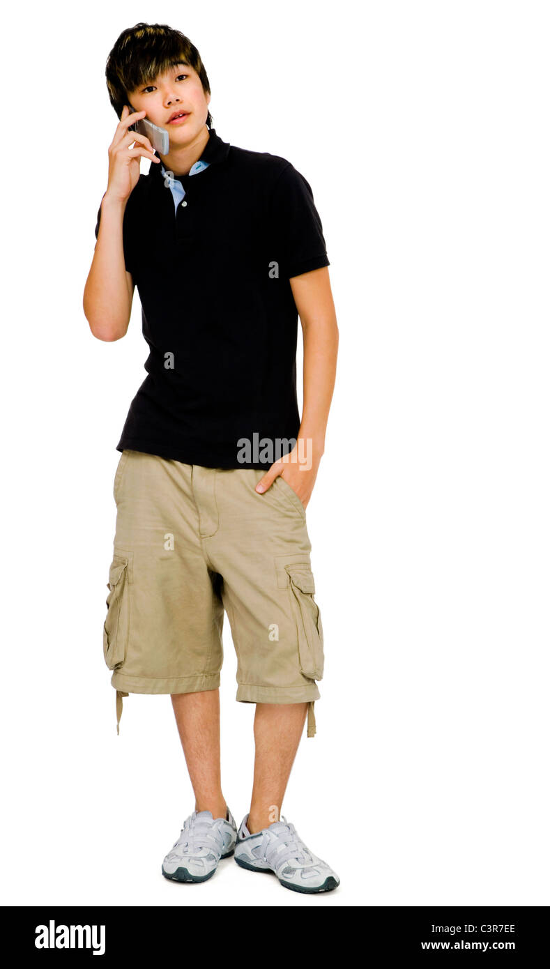 Portrait of a teenage boy talking on a mobile phone isolated over white ...