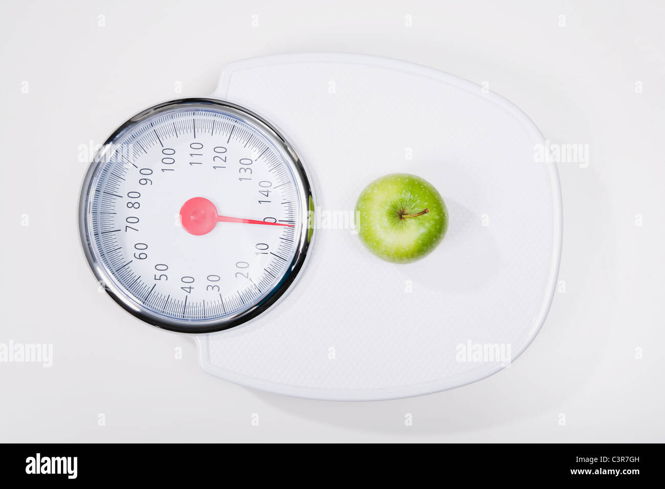Scale with green apple Stock Photo - Alamy