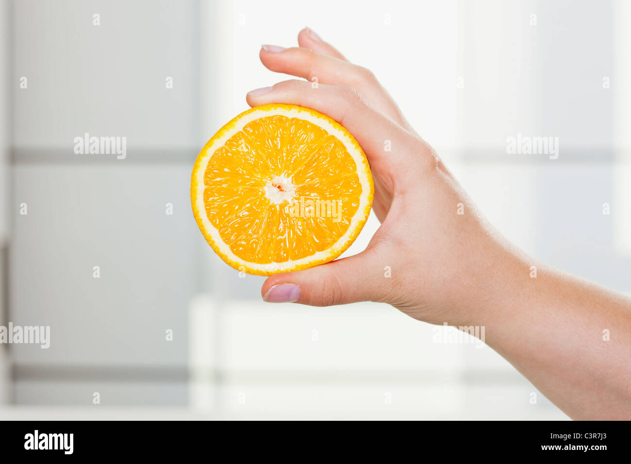 Germany, Cologne, Human hand holding half orange Stock Photo - Alamy