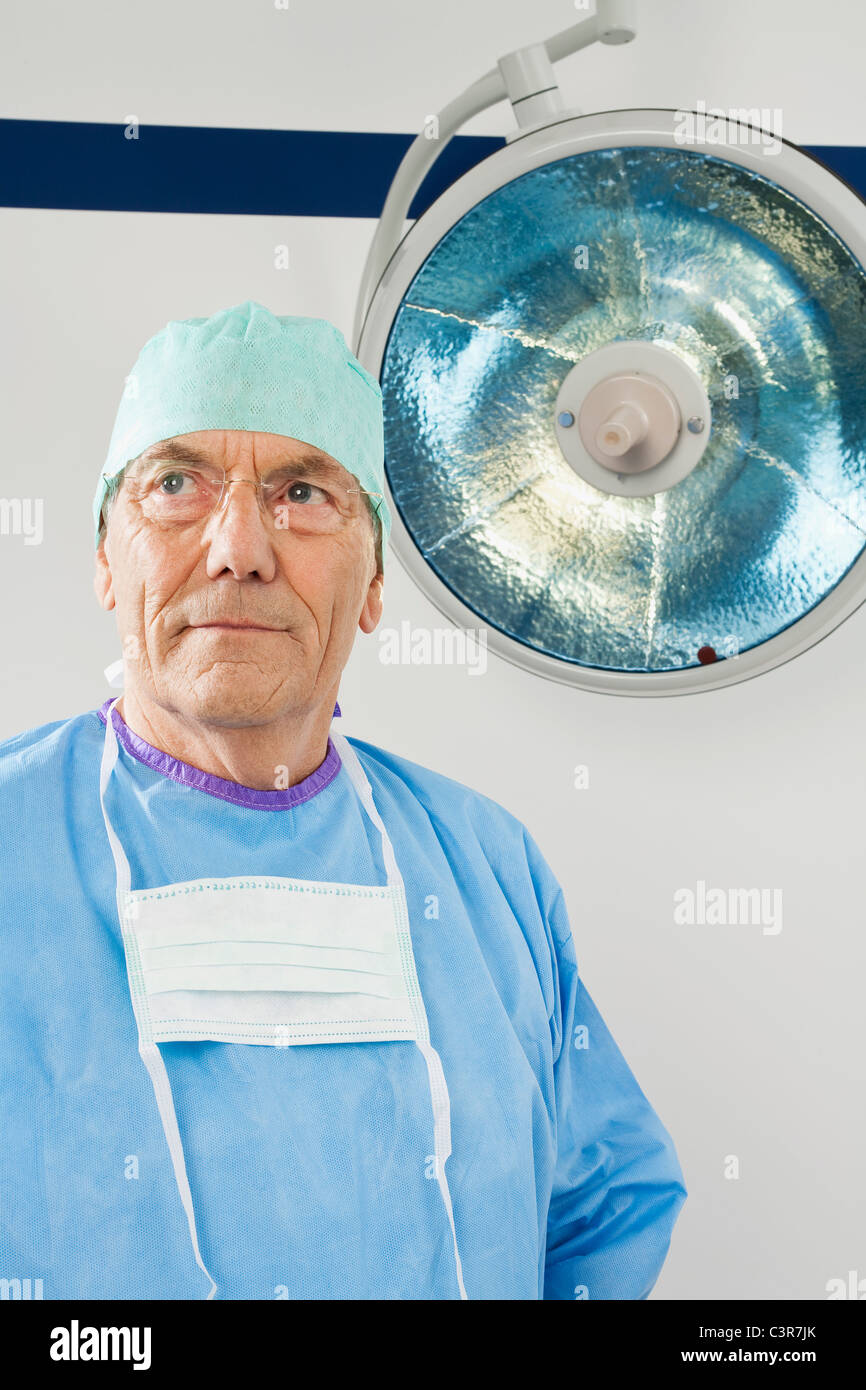 Germany, Munich, Senior doctor wearing surgical cap and mask, smiling ...