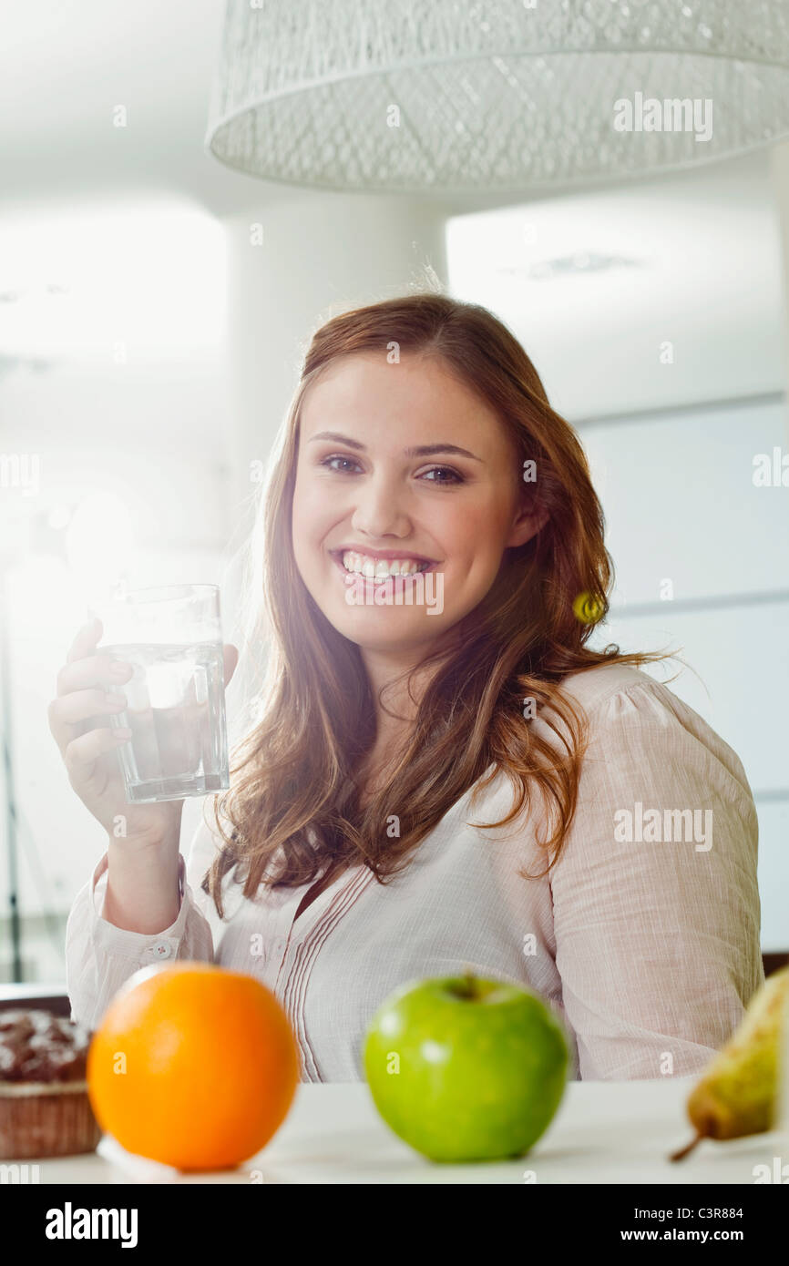 Germany, Cologne, Young woman with fruits, smiling, portrait Stock ...