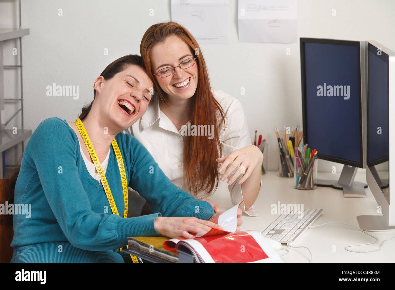 2 women laughing , work environment Stock Photo - Alamy