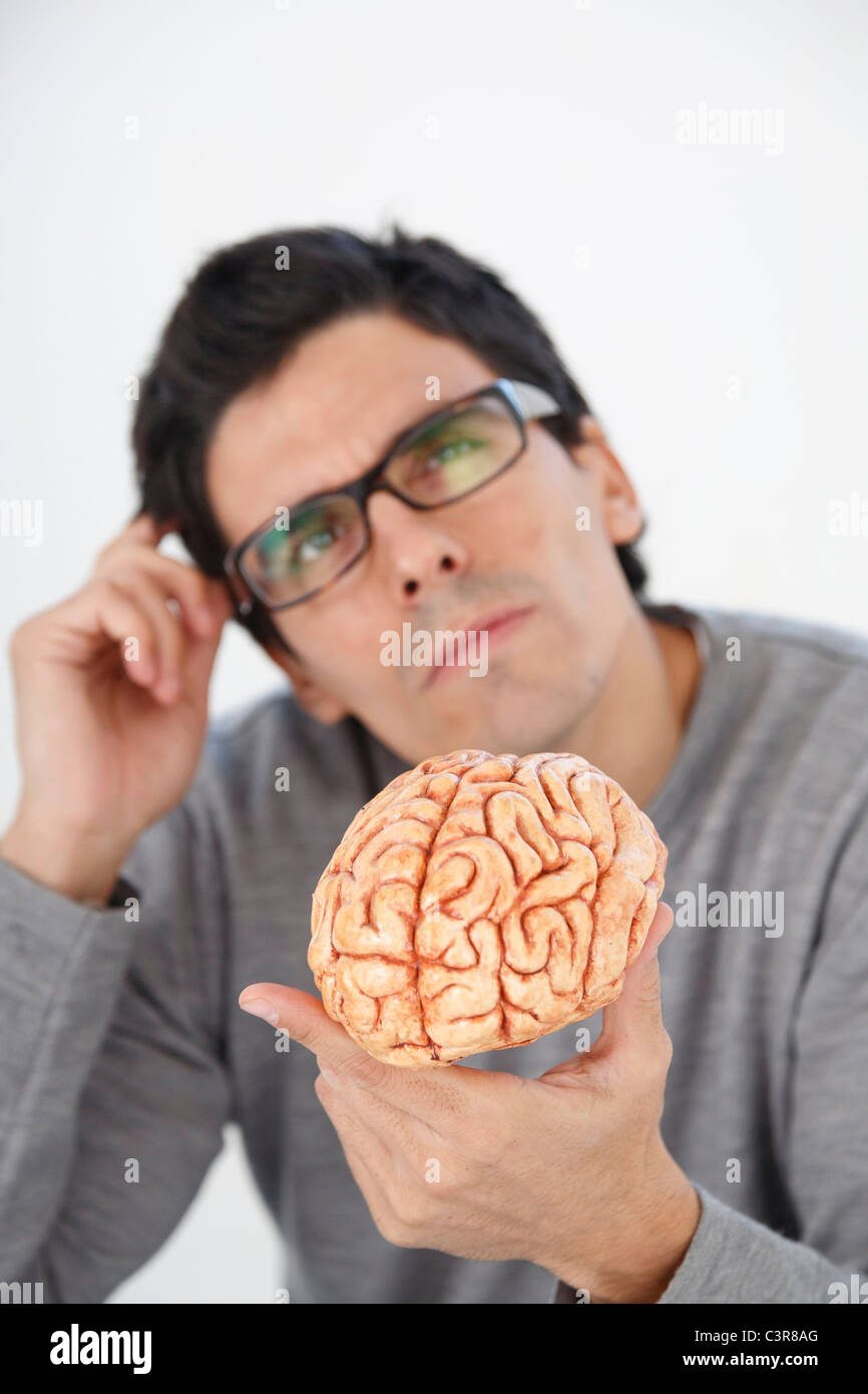 Man holding model brain, thinking Stock Photo - Alamy