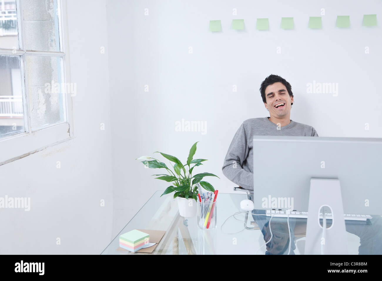 Man laughing at computer Stock Photo - Alamy