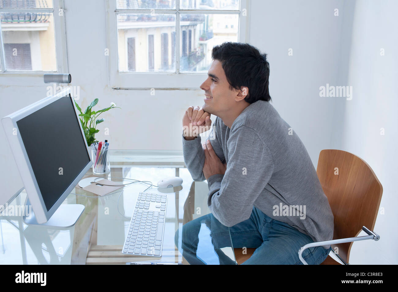 Man smiling at computer Stock Photo - Alamy