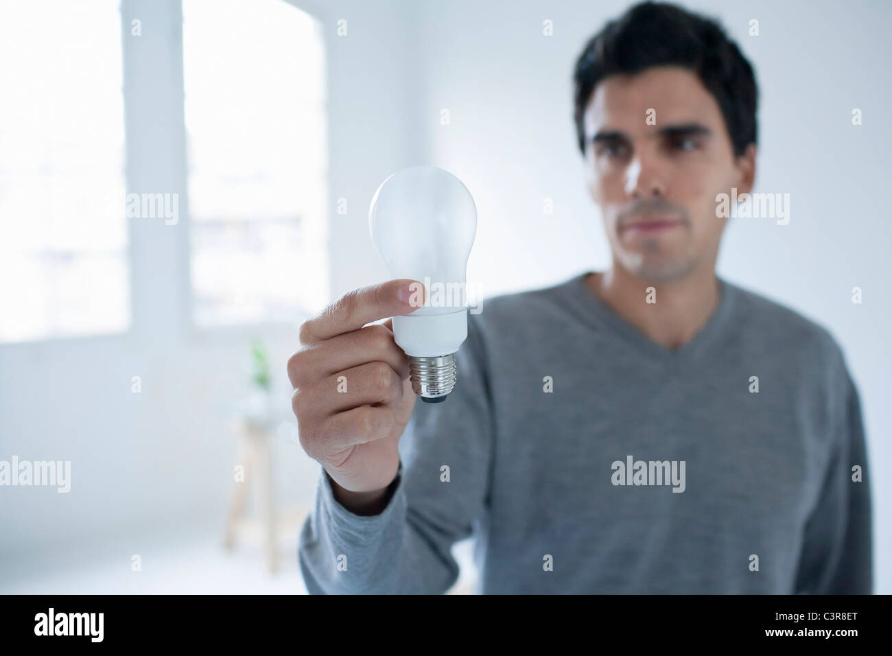 Man holding a lightbulb Stock Photo - Alamy