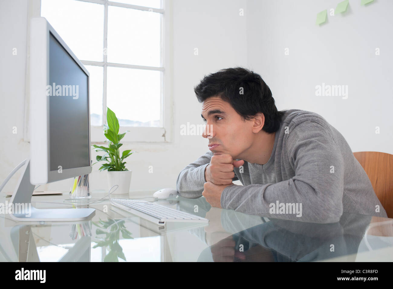 Man looking at computer Stock Photo - Alamy