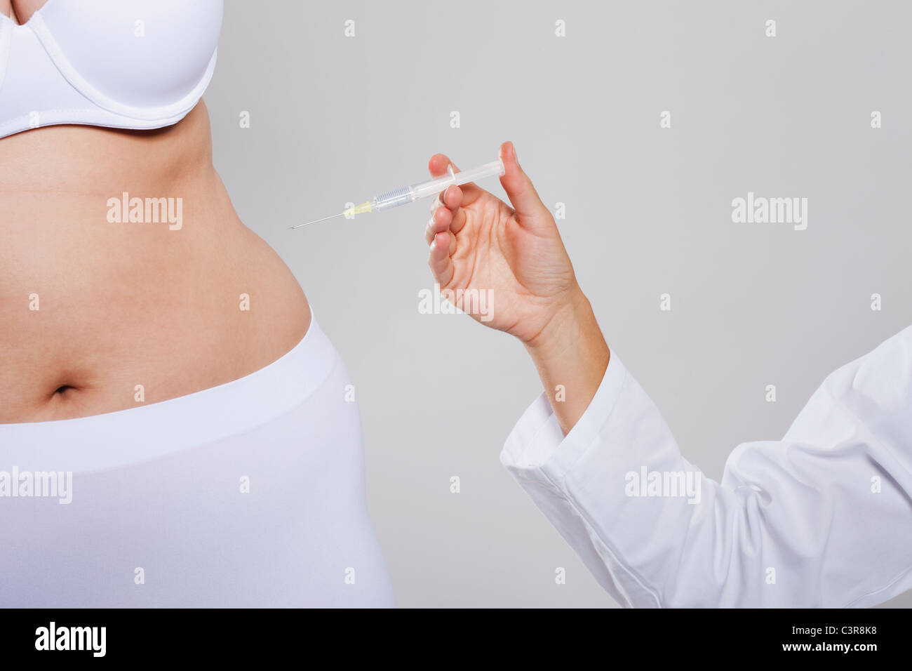 Germany, Cologne, Mid adult woman giving injection to young woman Stock ...