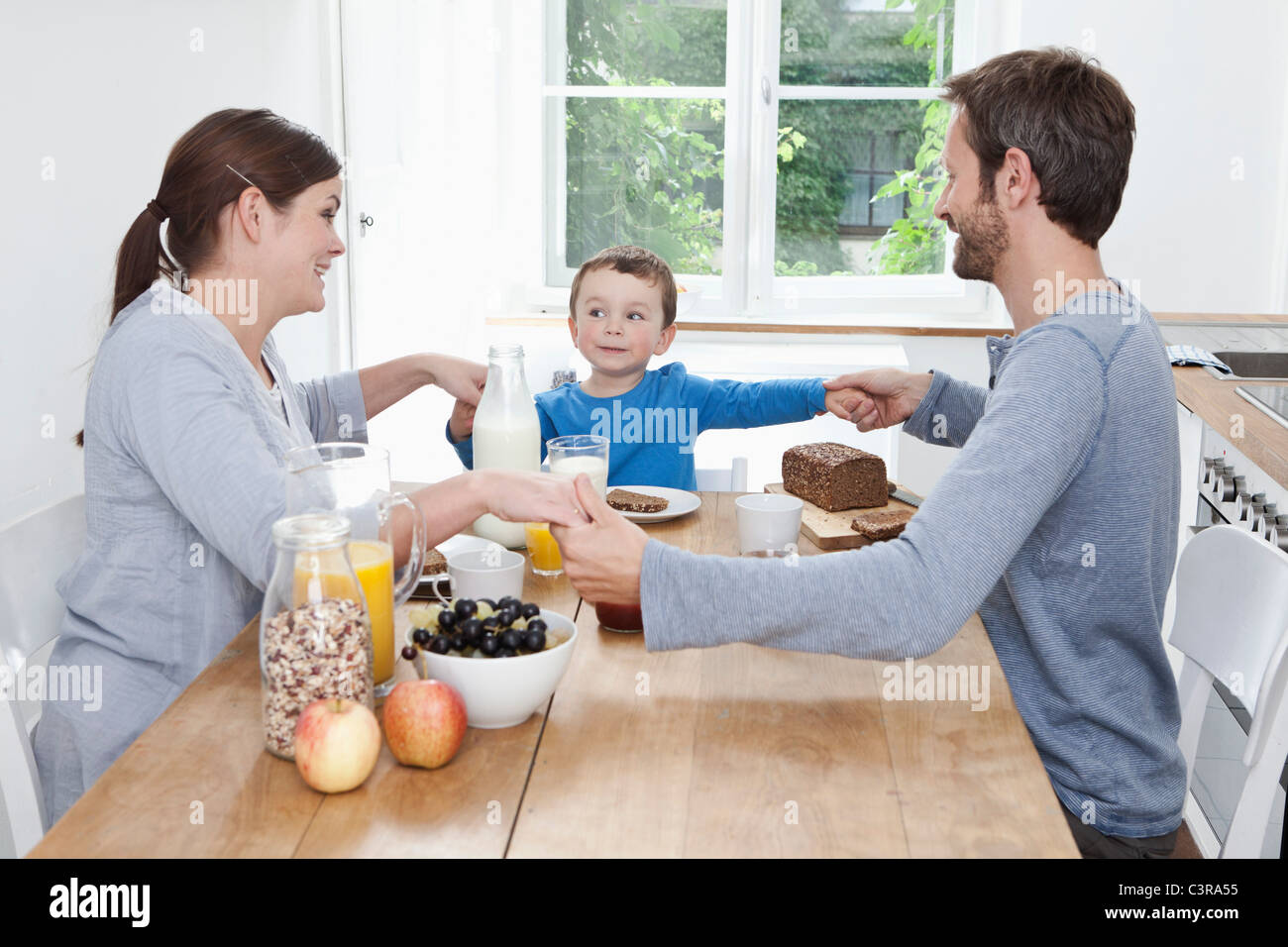 Germany, Bavaria, Munich, Family having breakfast together happily ...