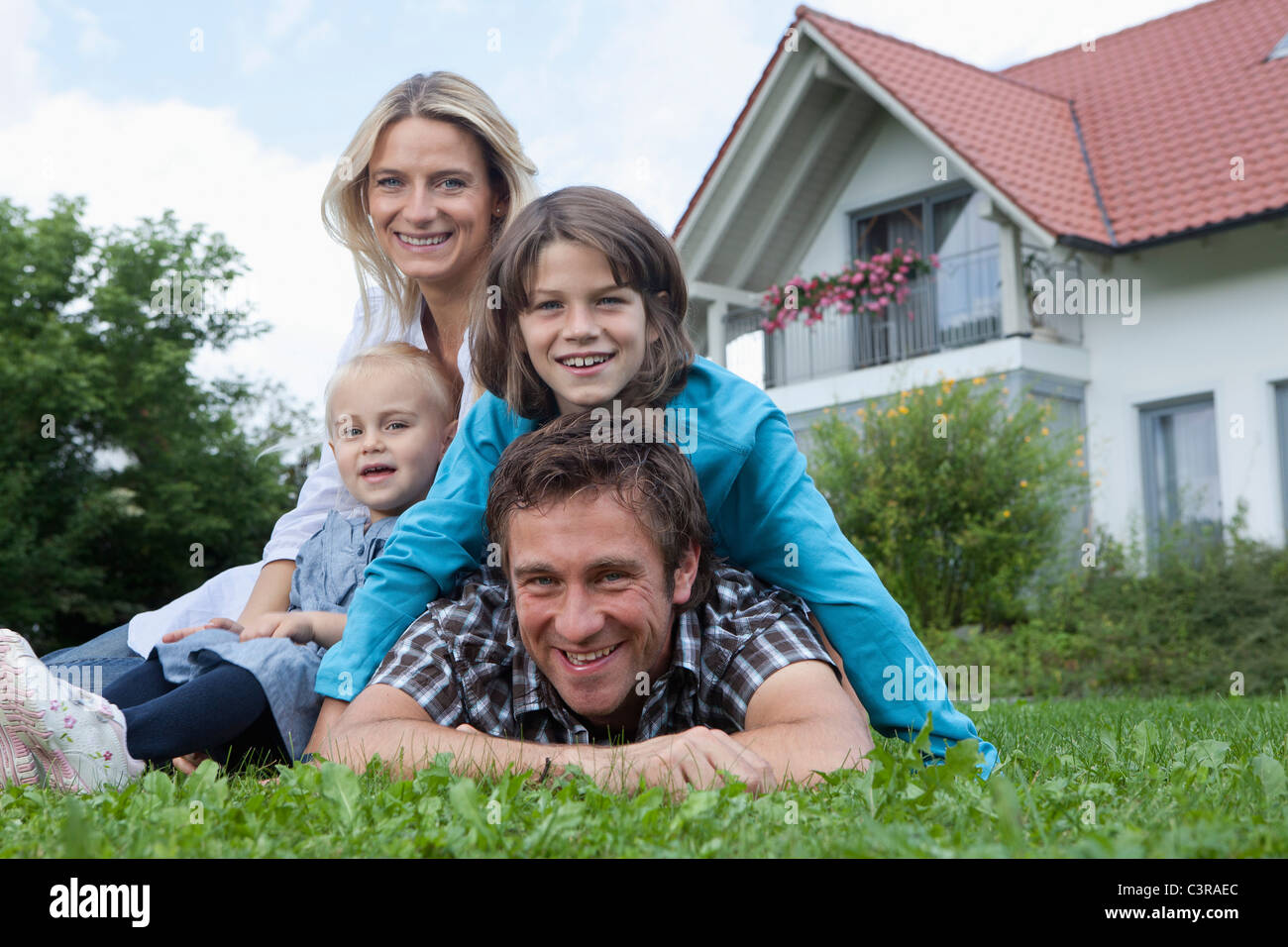 Germany, Munich, Family in front of house, smiling, portrait Stock ...