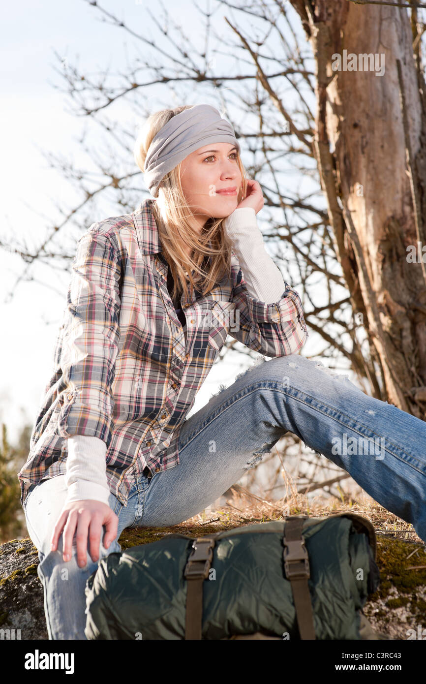 Camping young woman hiking with backpack sitting in countryside Stock ...