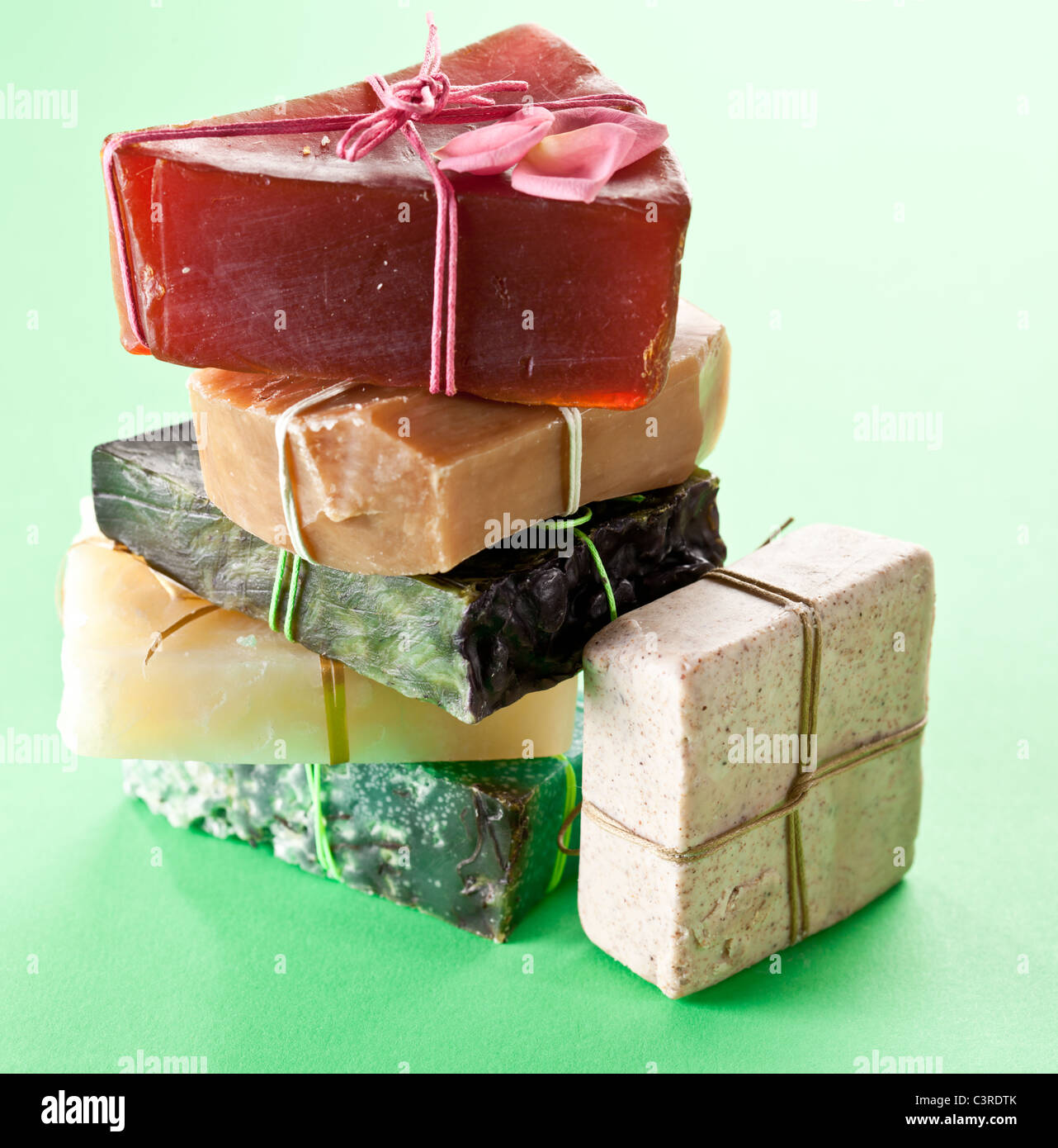 Pieces of different natural soap on a green background Stock Photo - Alamy