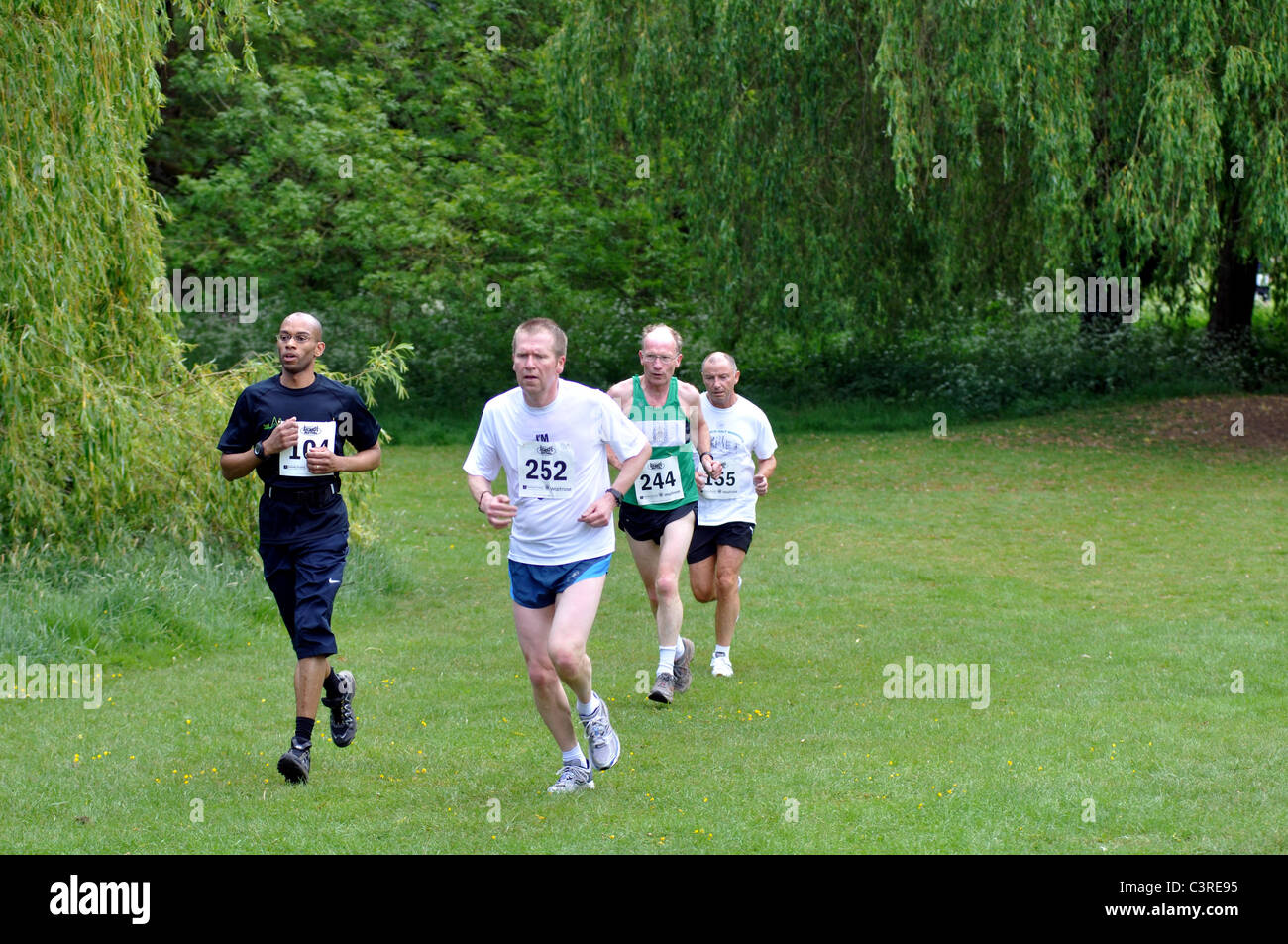 Men running in a race on grass Stock Photo - Alamy