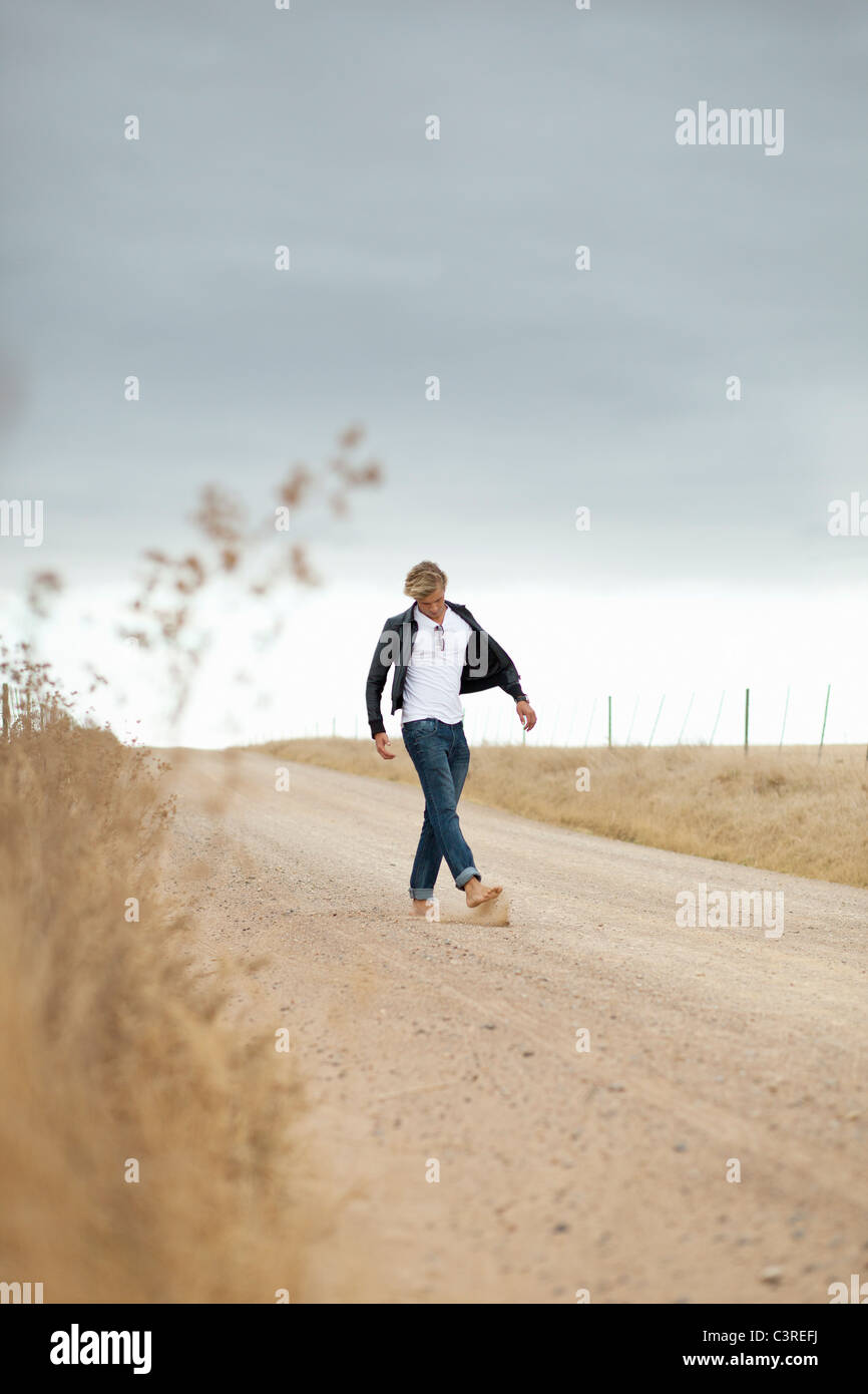 Boy kicking stone Stock Photo - Alamy