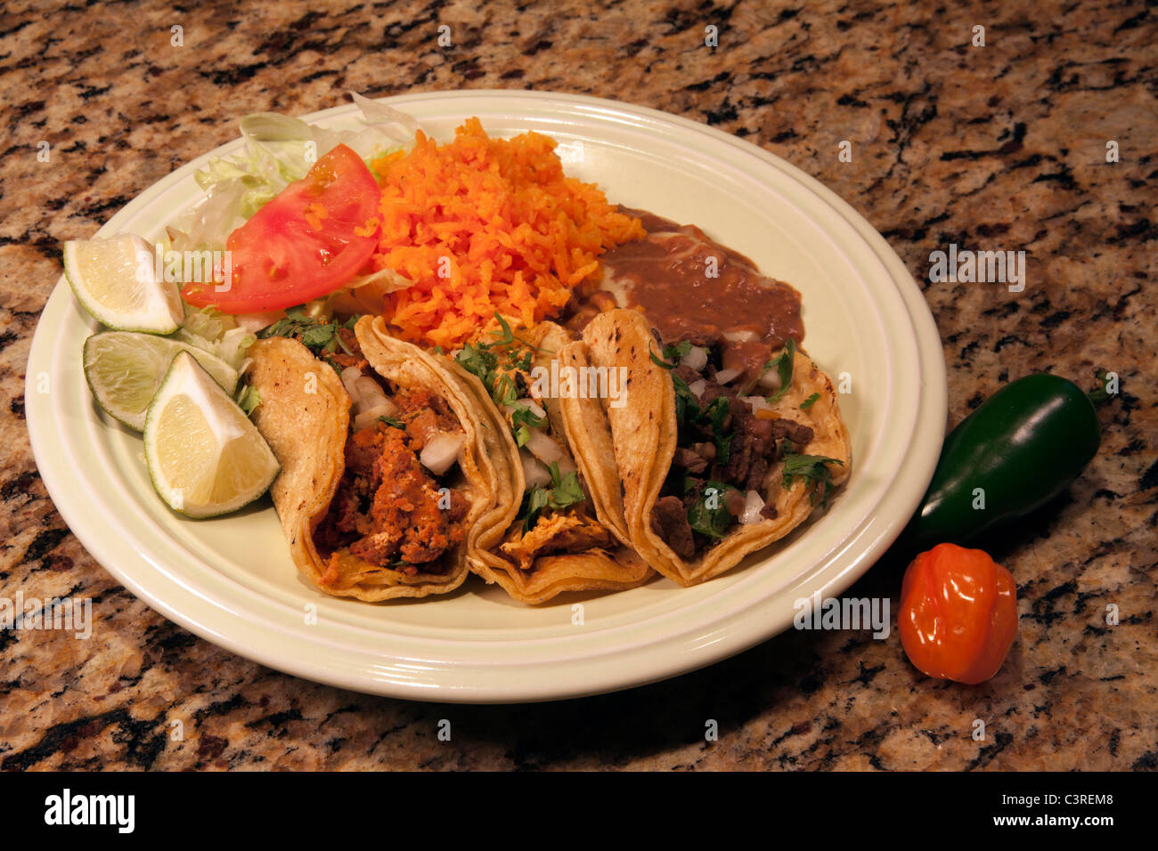 Plate of three tacos with rice and beans Stock Photo - Alamy