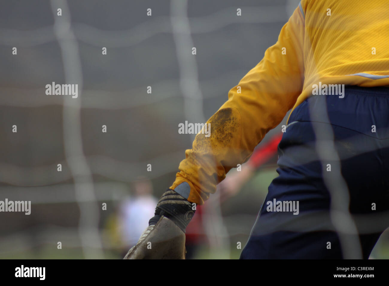 Goalkeeper playing football in front of football net Stock Photo - Alamy