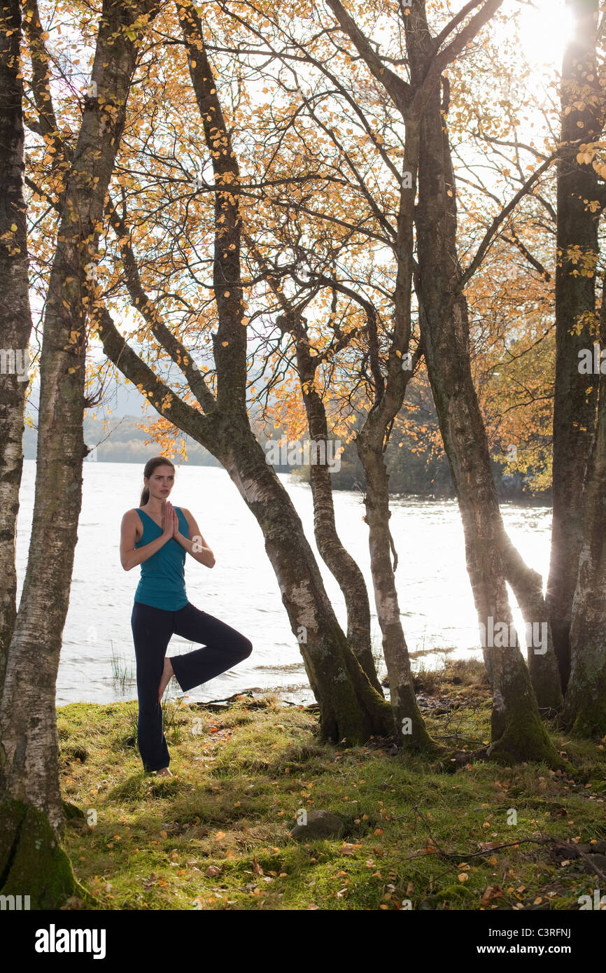 woman practising yoga position amongst trees Stock Photo - Alamy