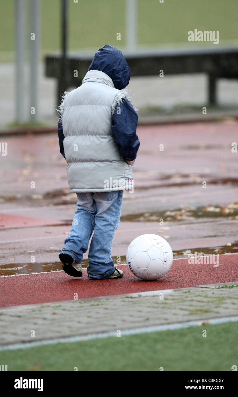 A lonely child with a football Stock Photo - Alamy
