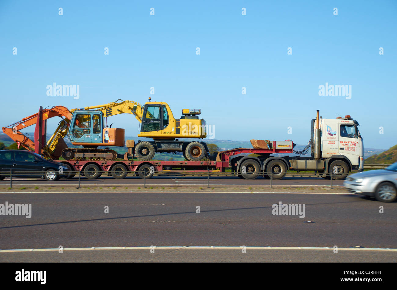 Diggers on a flatbed lorry on the M62 motorway Stock Photo - Alamy