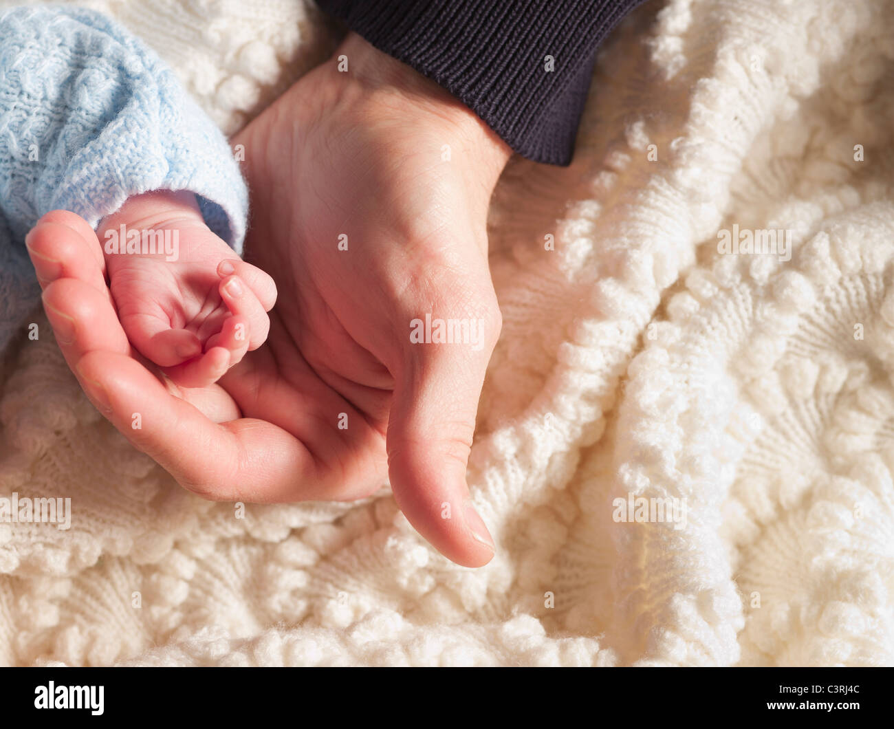 Large hand holding tiny newborn's hand Stock Photo - Alamy