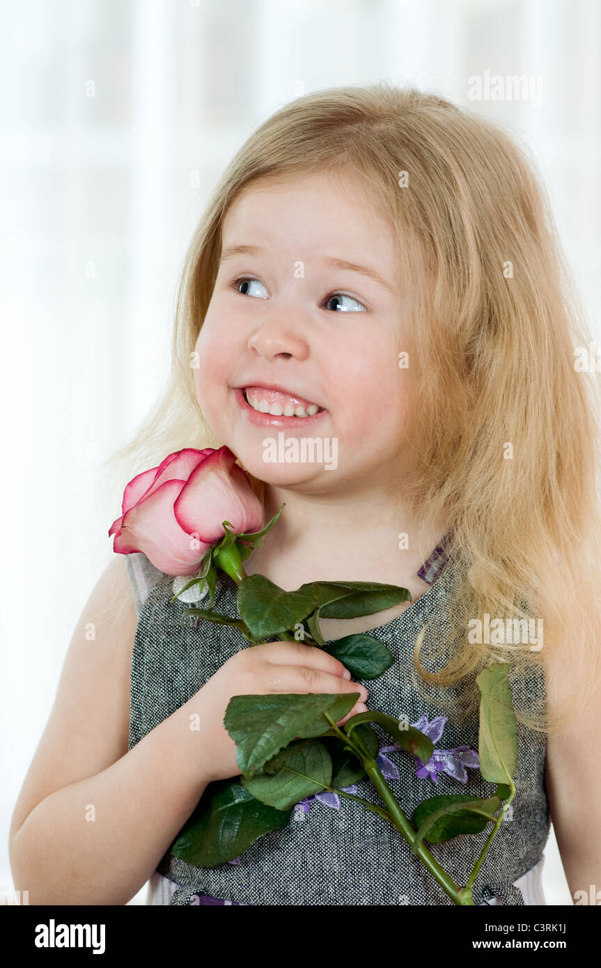beautiful little girl with pink of rose Stock Photo - Alamy