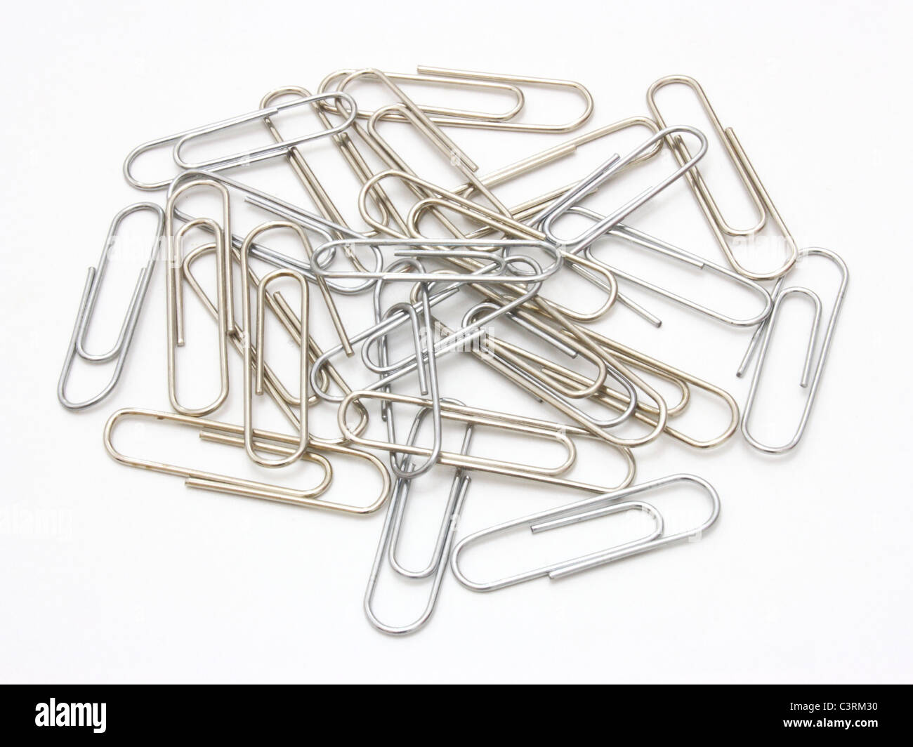Writing metal paper clips lie in bulk on a white background of a paper ...