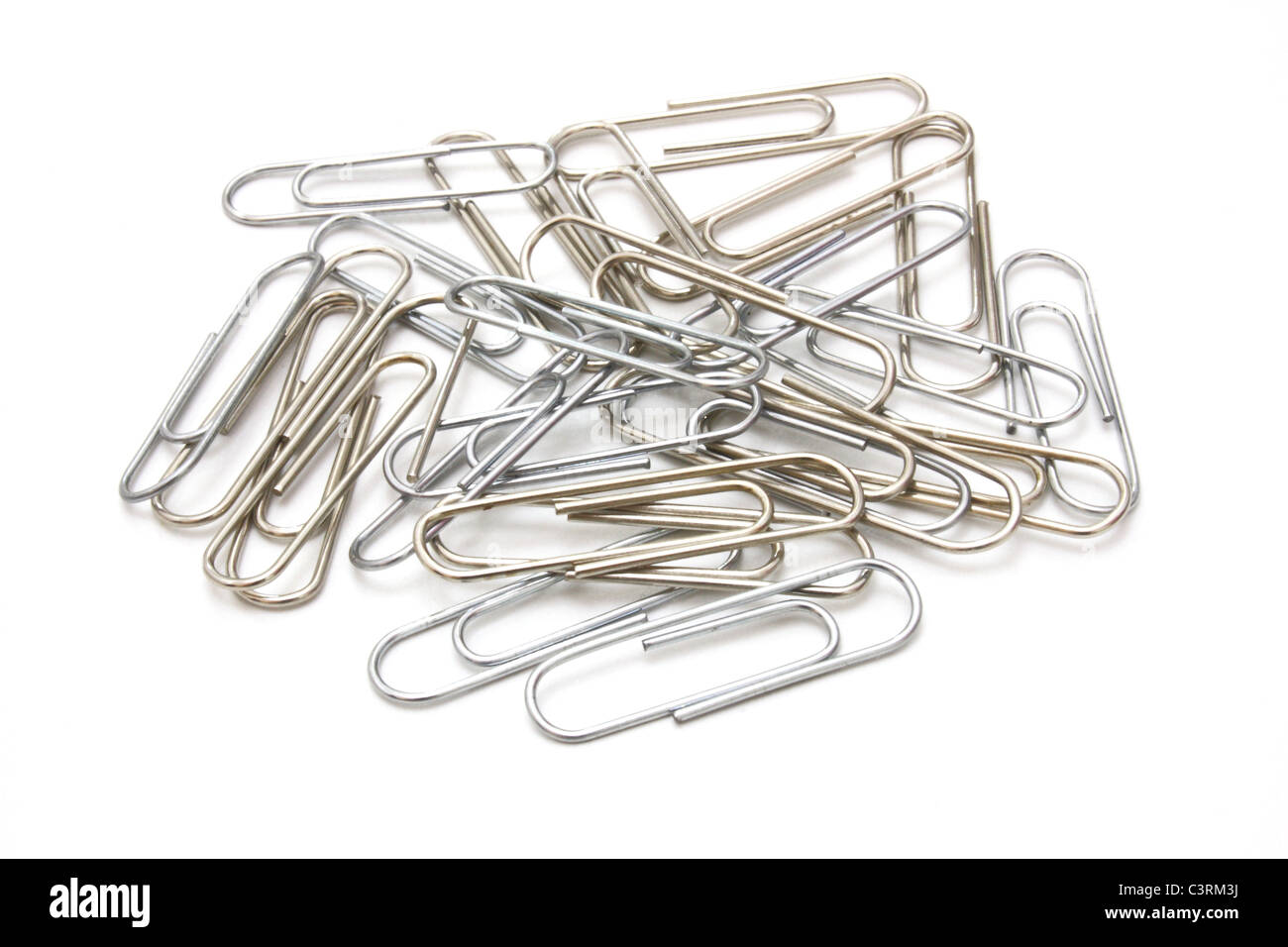 Writing metal paper clips lie in bulk on a white background of a paper ...