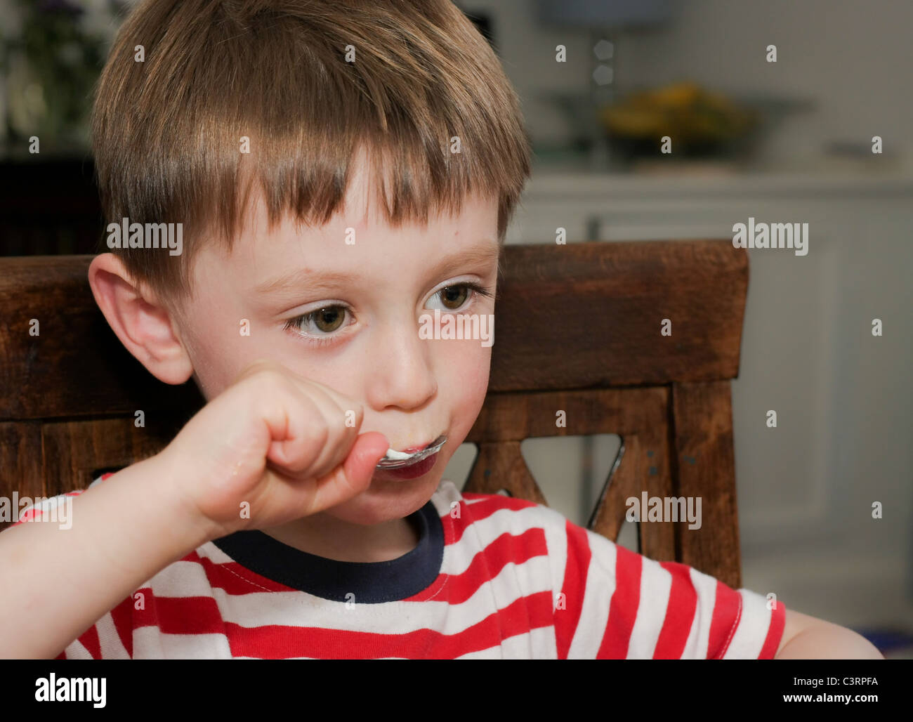 Little boy eating with a spoon Stock Photo - Alamy