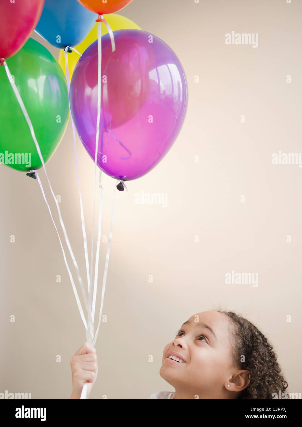 African American girl holding helium balloons Stock Photo - Alamy