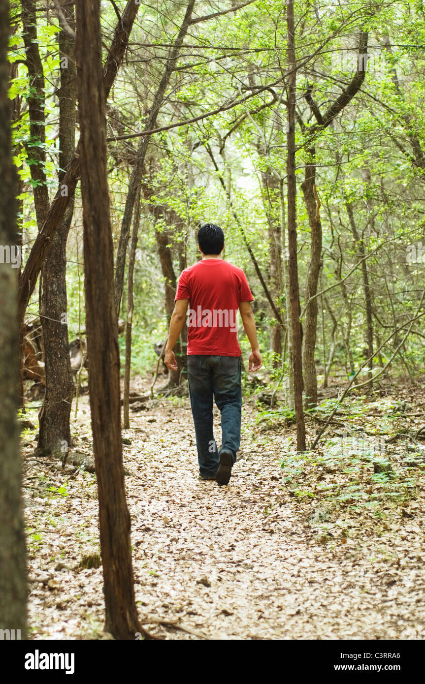 Hispanic man walking on path in woods Stock Photo - Alamy