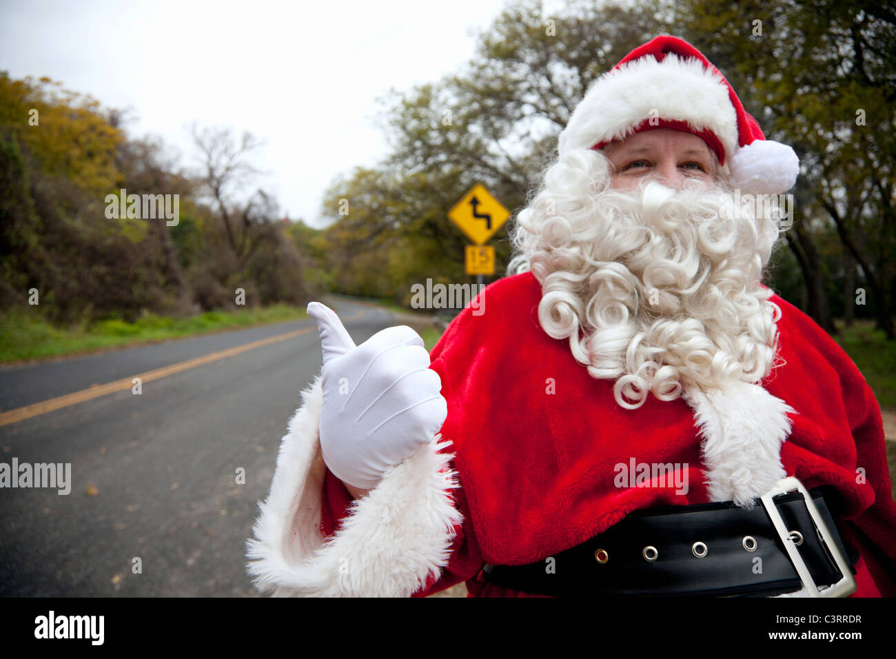 Santa hitchhiking at roadside Stock Photo - Alamy