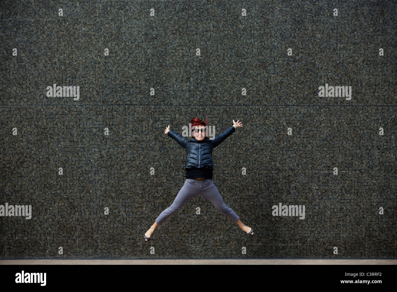 Korean woman jumping on city sidewalk Stock Photo - Alamy