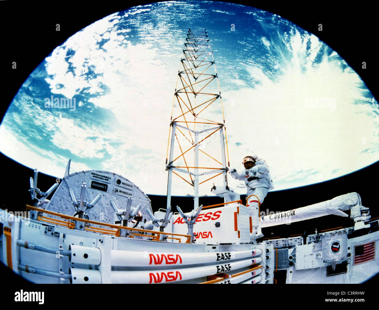 An astronaut manually constructs a truss tower from the Space Shuttle ...