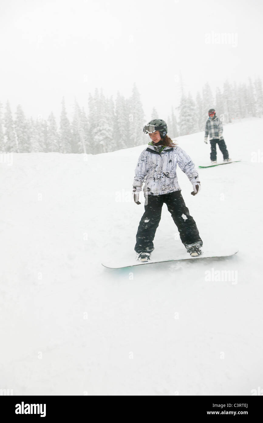 Snowboarders descending ski slope Stock Photo - Alamy