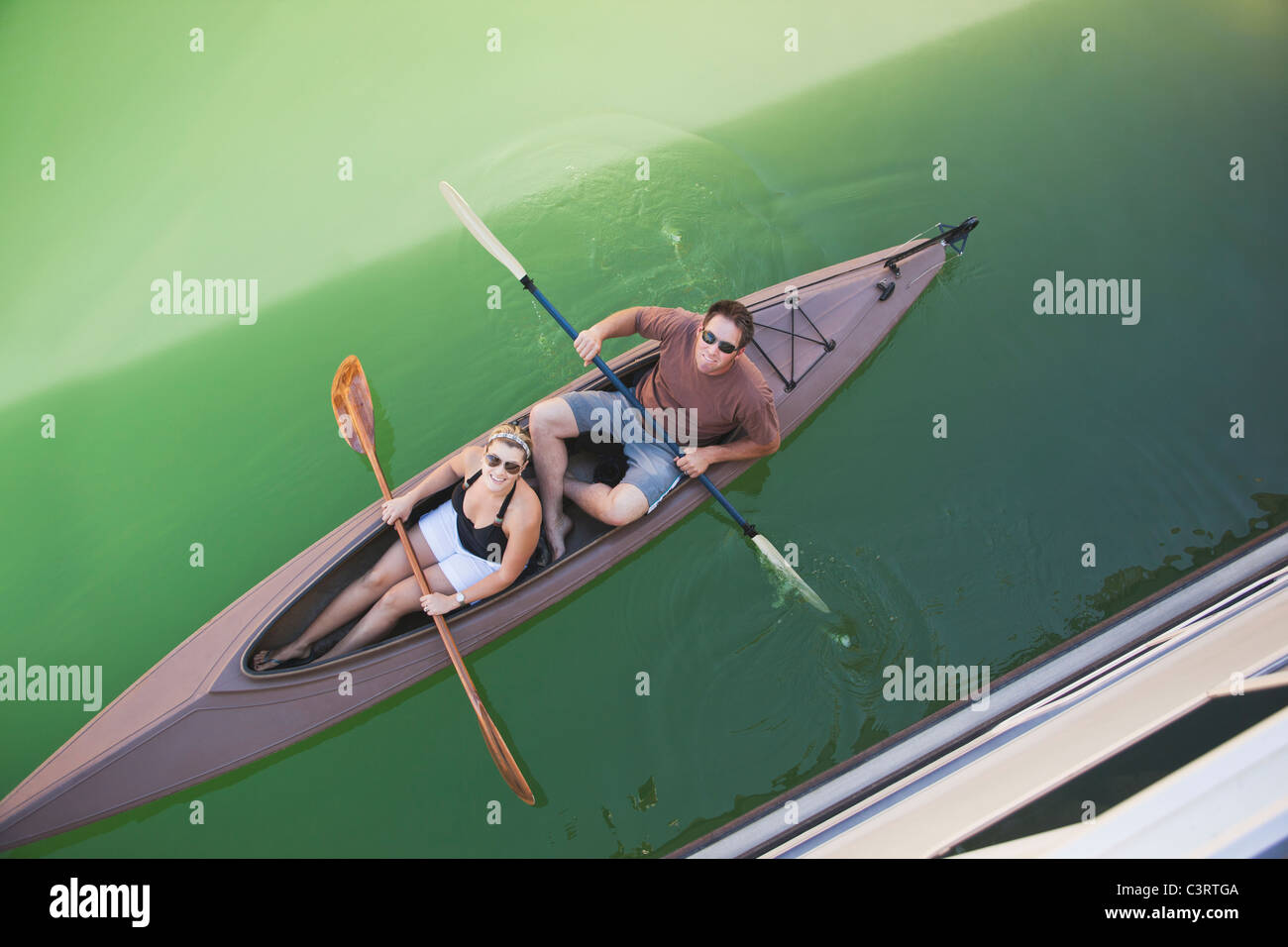 Caucasian couple rowing canoe Stock Photo - Alamy