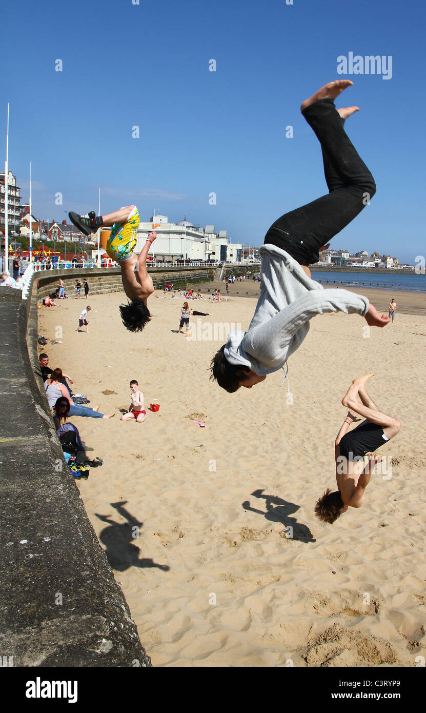 Lads doing somersaults off sea wall Stock Photo - Alamy