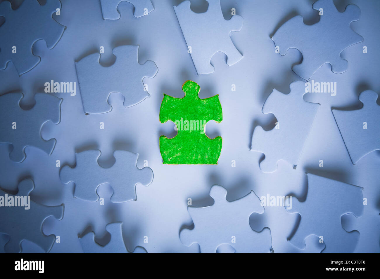 One Green jigsaw piece among blank ones Stock Photo - Alamy
