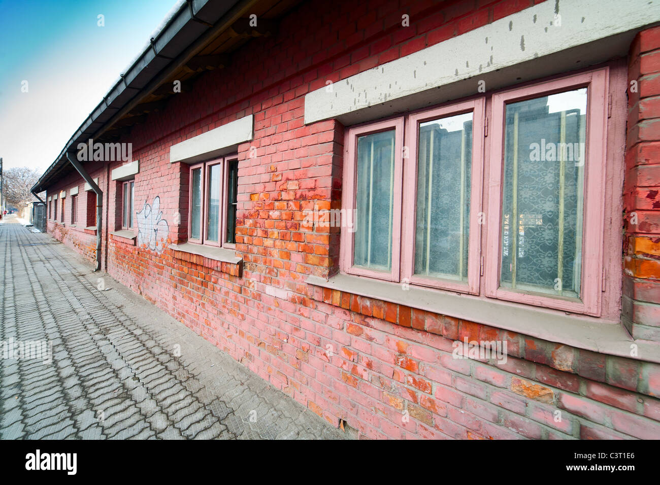 Brick wall with windows of a building near sidewalk Stock Photo - Alamy