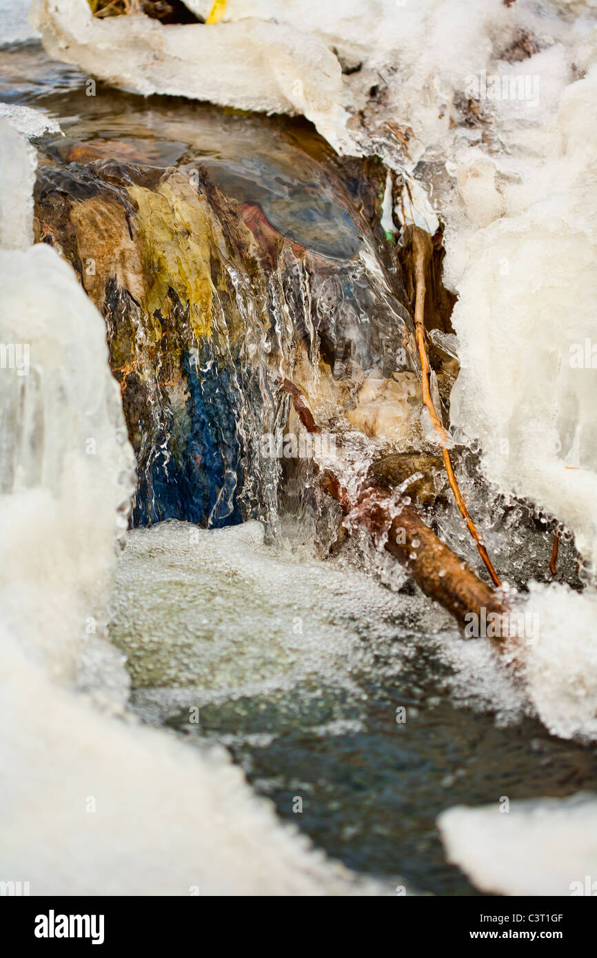 A creek flowing fast among ice formations Stock Photo - Alamy