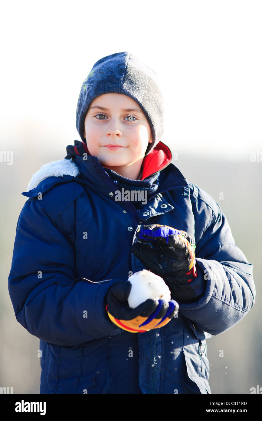 Portrait with a cute kid with a snowball Stock Photo - Alamy