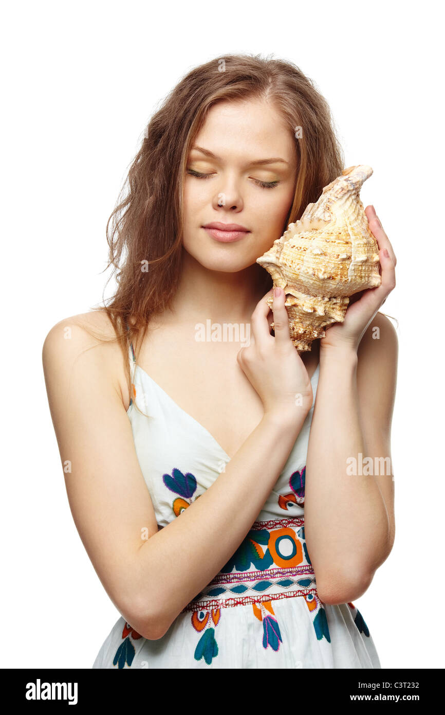 Portrait of a young girl listening to the seashell Stock Photo - Alamy
