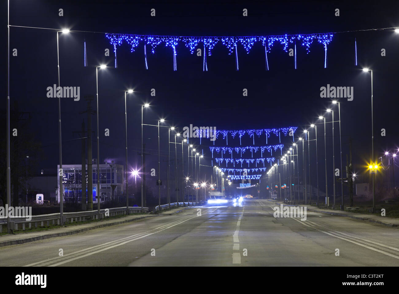 Road at night with blue light decorations and car lights seen in the ...