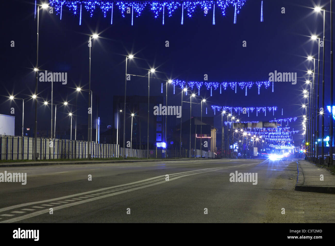 Road at night with blue light decorations and car lights seen in the ...
