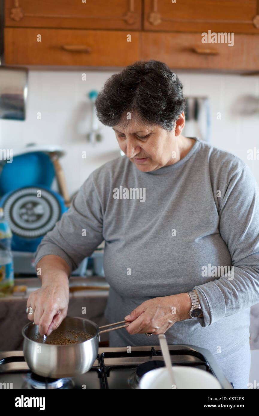 Senior woman cooking on a stove in bright daylight Stock Photo - Alamy
