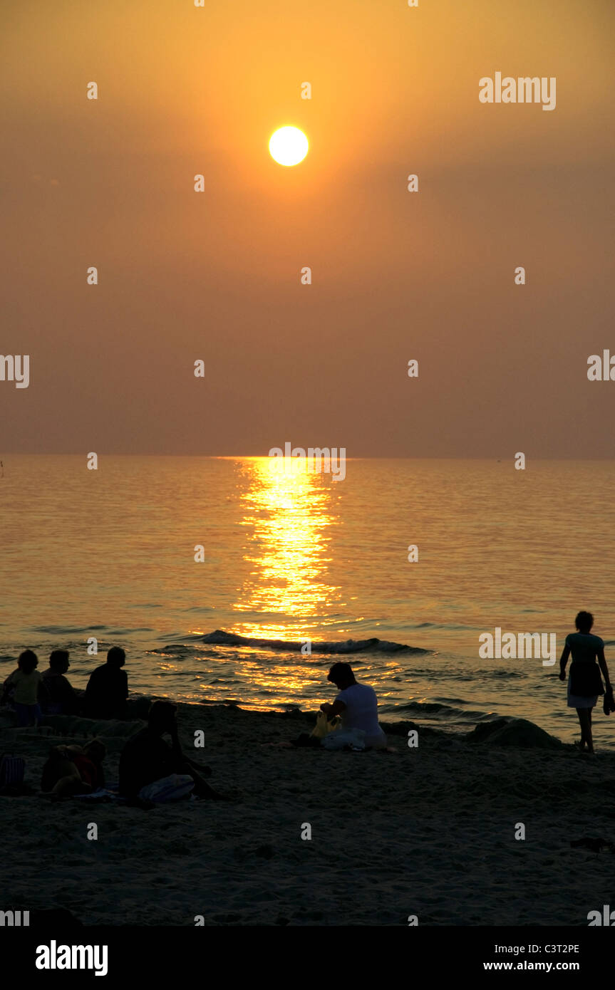Group of people is looking at the sunset at the seaside Stock Photo - Alamy